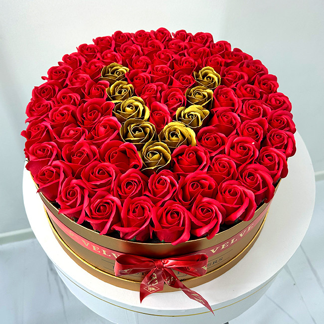 Aranjament floral personalizat cu litera V, in cutie rotunda aurie cu 55 trandafiri de sapun