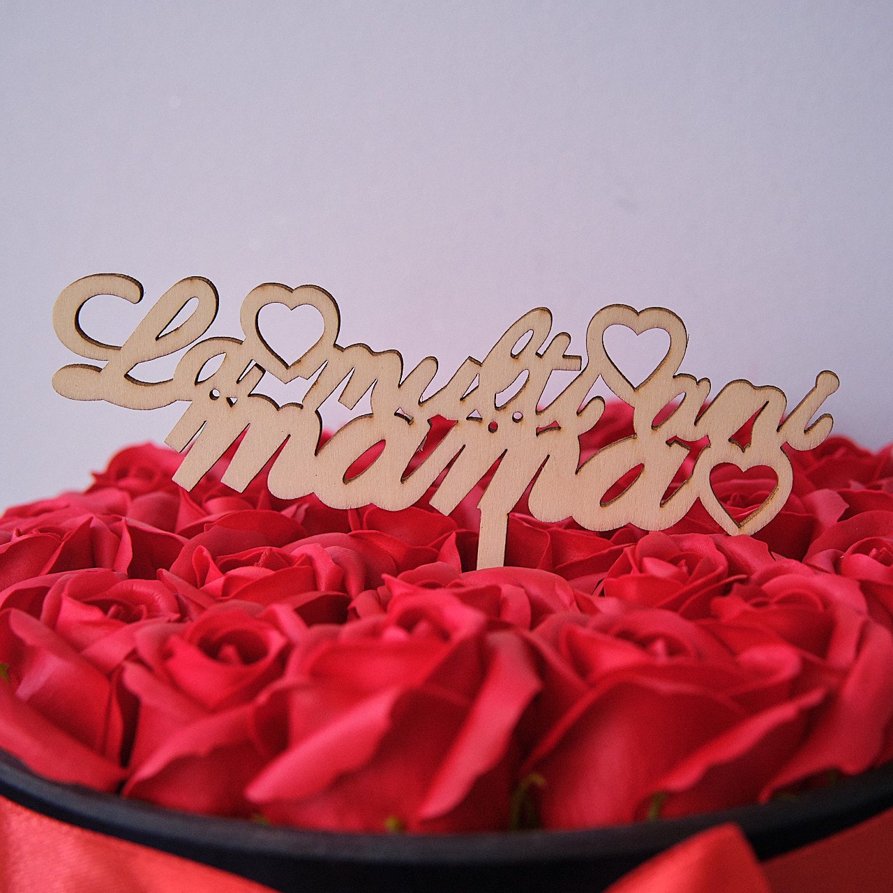 Aranjament floral in cutie rotunda neagra, cu 25 trandafiri rosii din sapun si mesaj "La multi ...