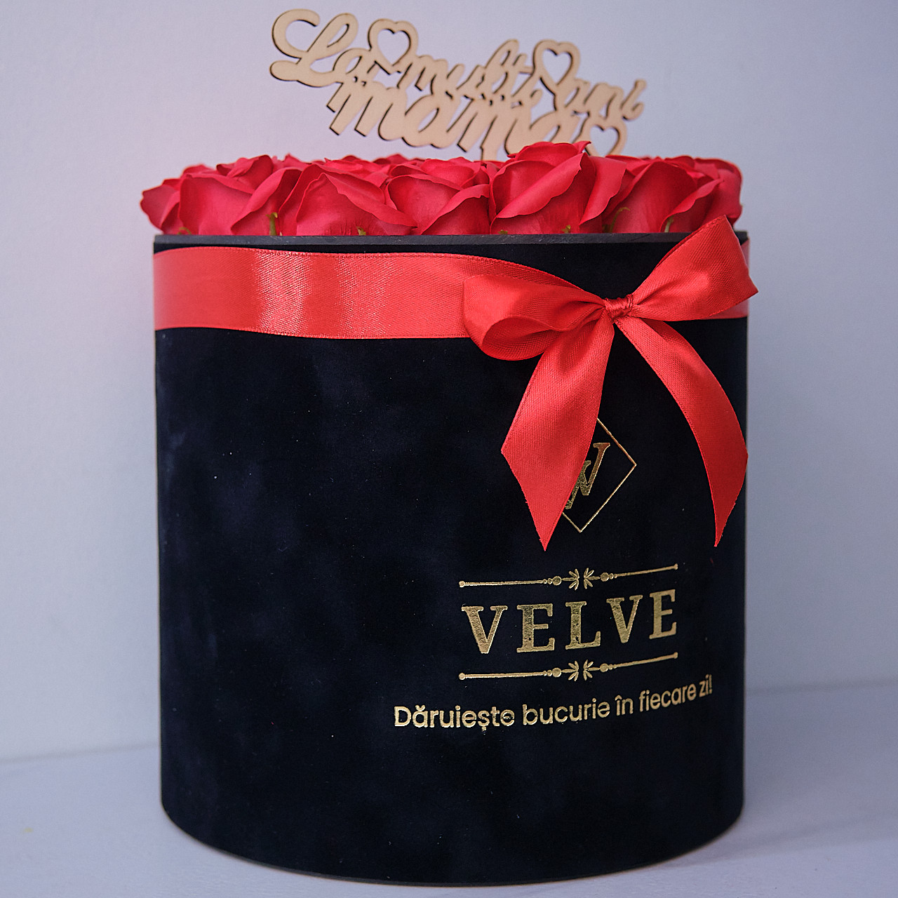 Aranjament floral in cutie rotunda neagra, cu 25 trandafiri rosii din sapun si mesaj "La multi ...