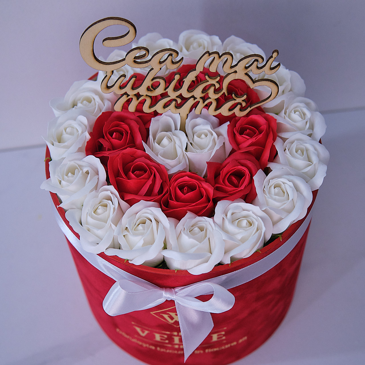 Aranjament floral in cutie rotunda rosie, cu 25 trandafiri albi/rosii din sapun si mesaj "Cea ...