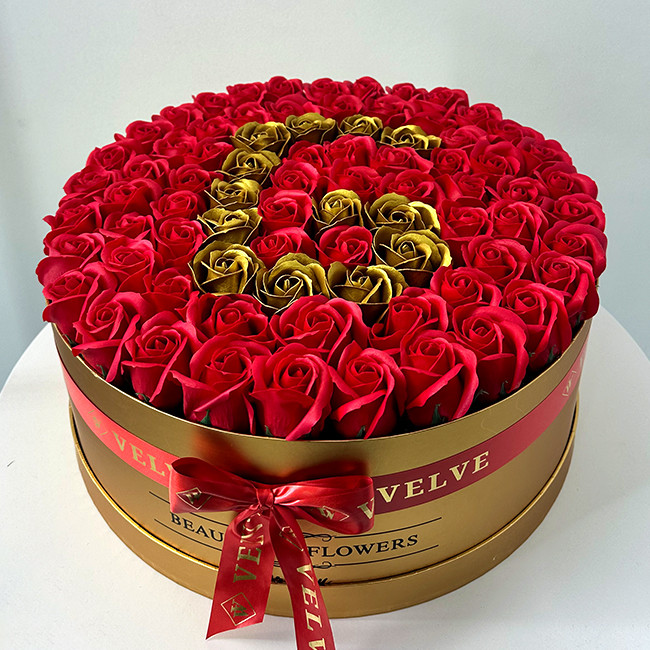 Aranjament floral personalizat cu litera G, in cutie rotunda aurie cu 55 trandafiri de sapun
